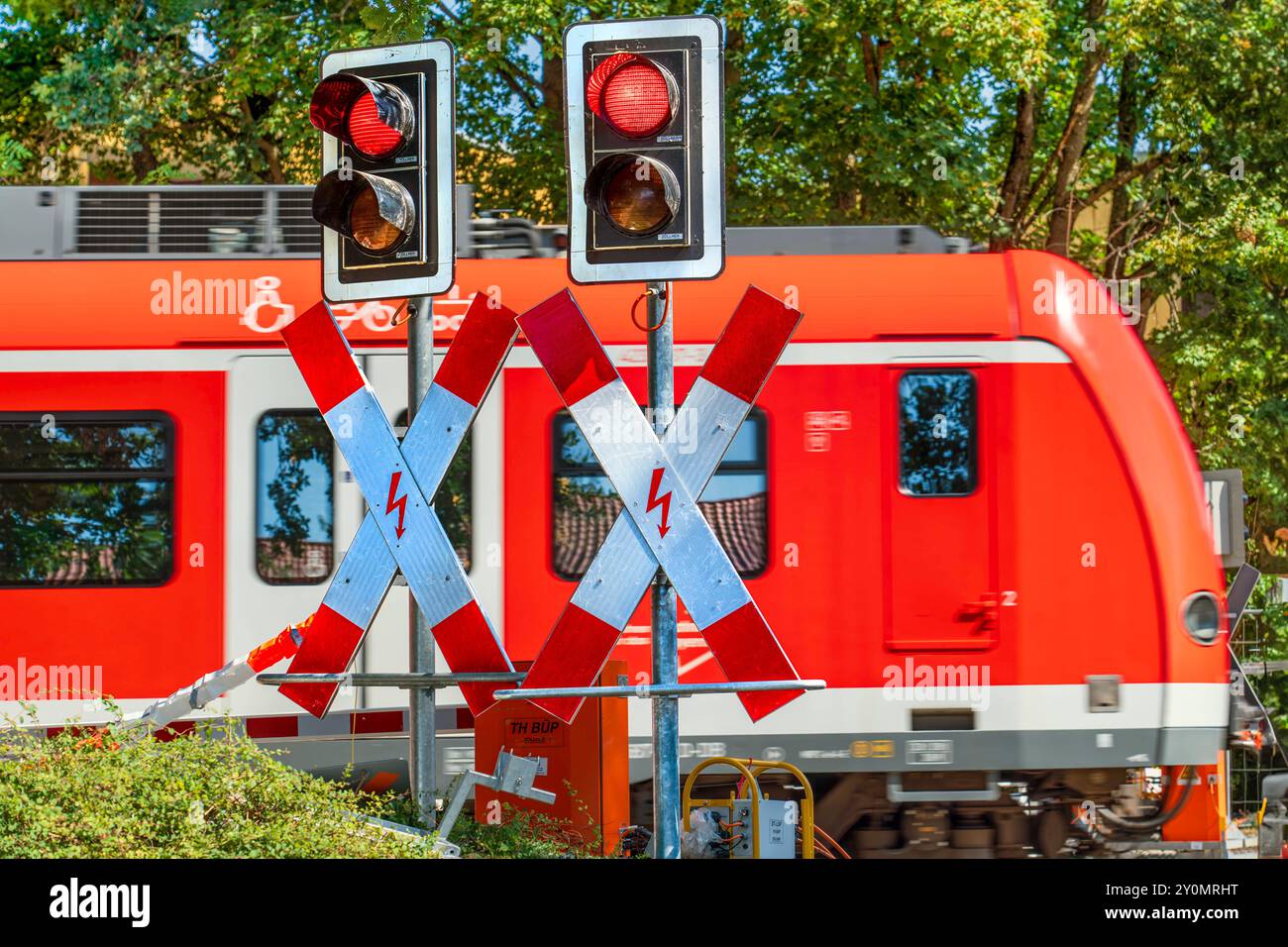 Bahnübergang der Münchener S-Bahn, rote Ampel, Zug fährt durch ...