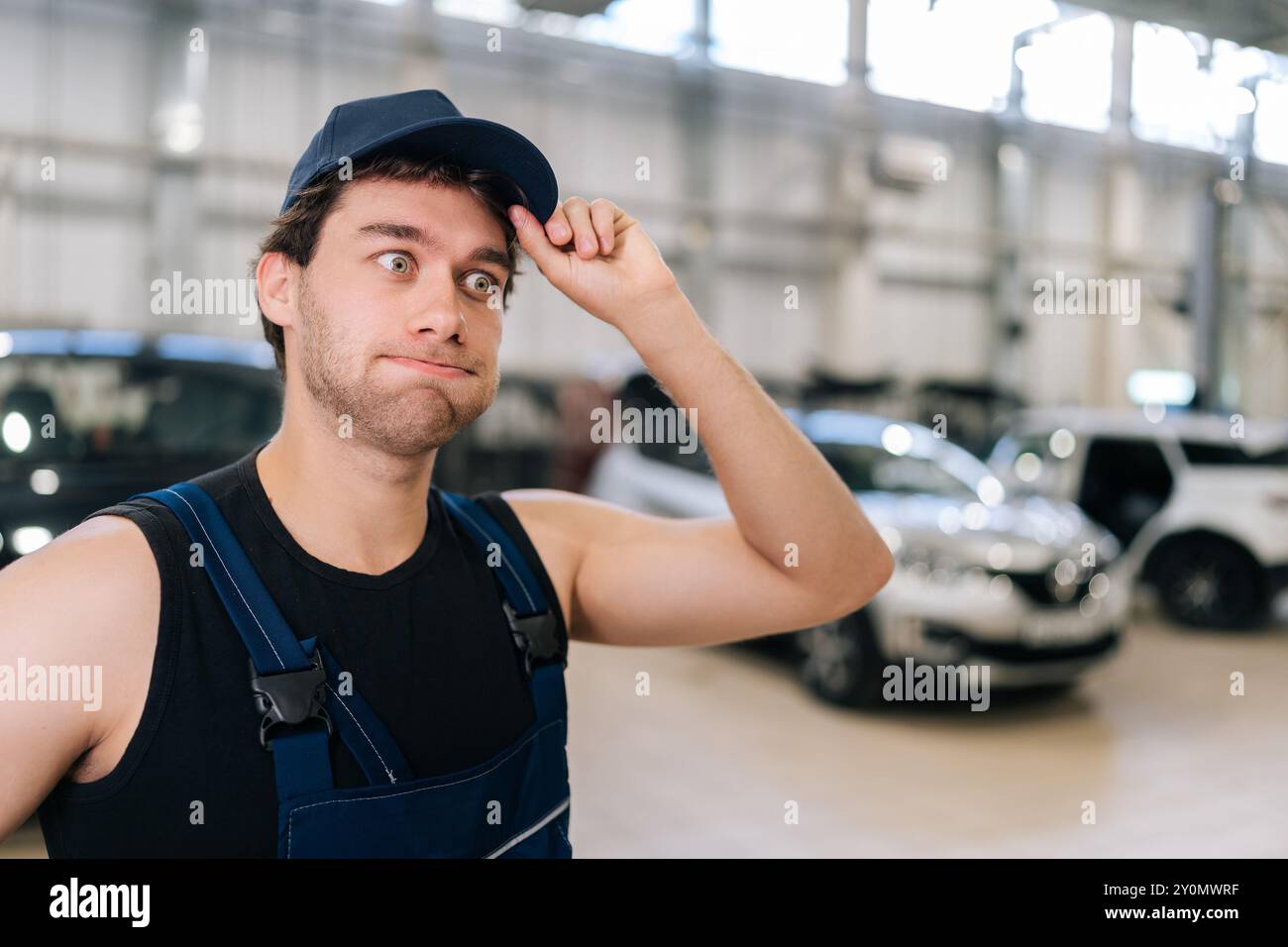 Closeup face of pensive thoughtful male mechanic in uniform holding ...