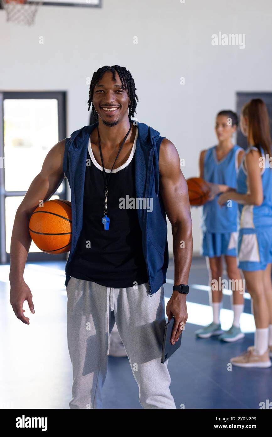 male african American basketball coach holding ball and whistle ...