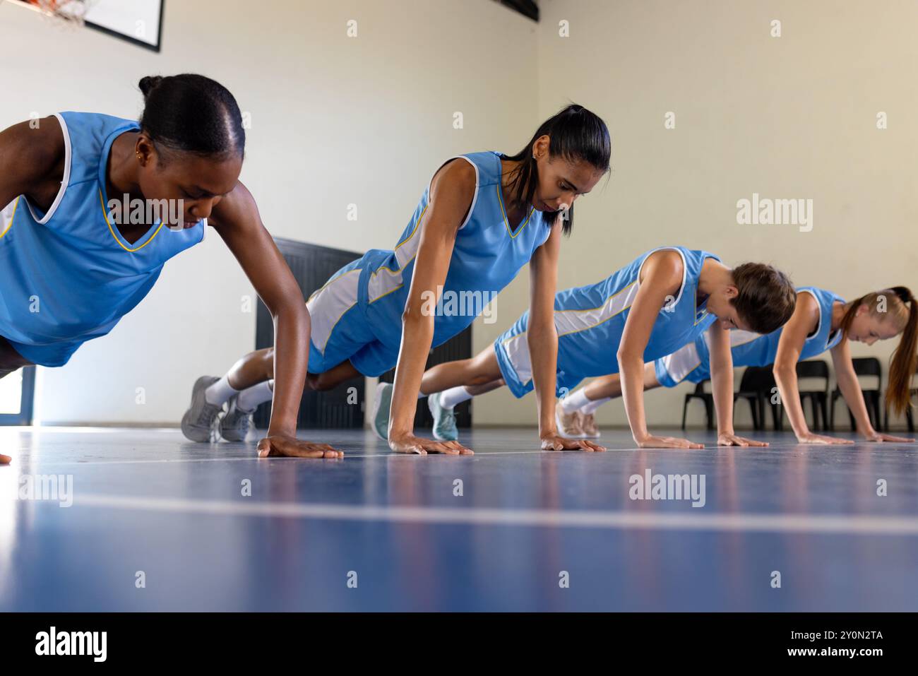 Doing push-ups on court, basketball team training in gym Stock Photo ...