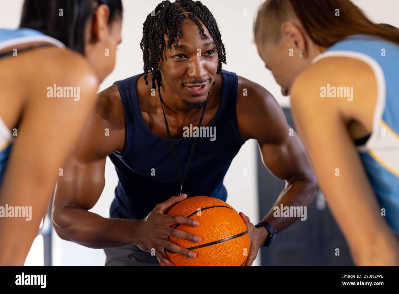 Coaching female basketball players, man holding basketball and giving ...