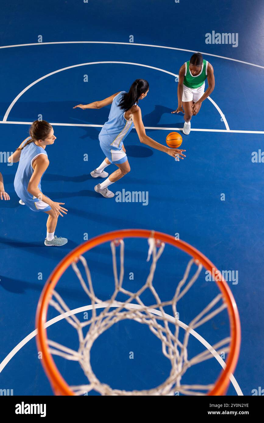 Playing basketball, female athletes dribbling and defending on indoor ...