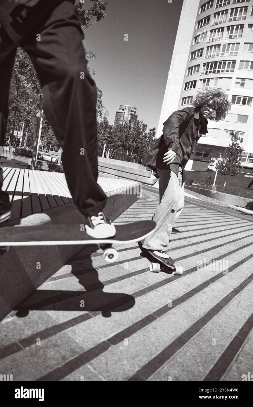 Young stylish men skateboarding, turning ordinary pavement into a ...