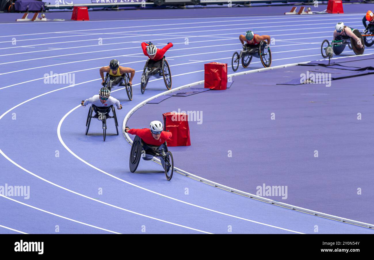 Paralympic athletes racing at the Women's 5000 m wheelchair final race ...