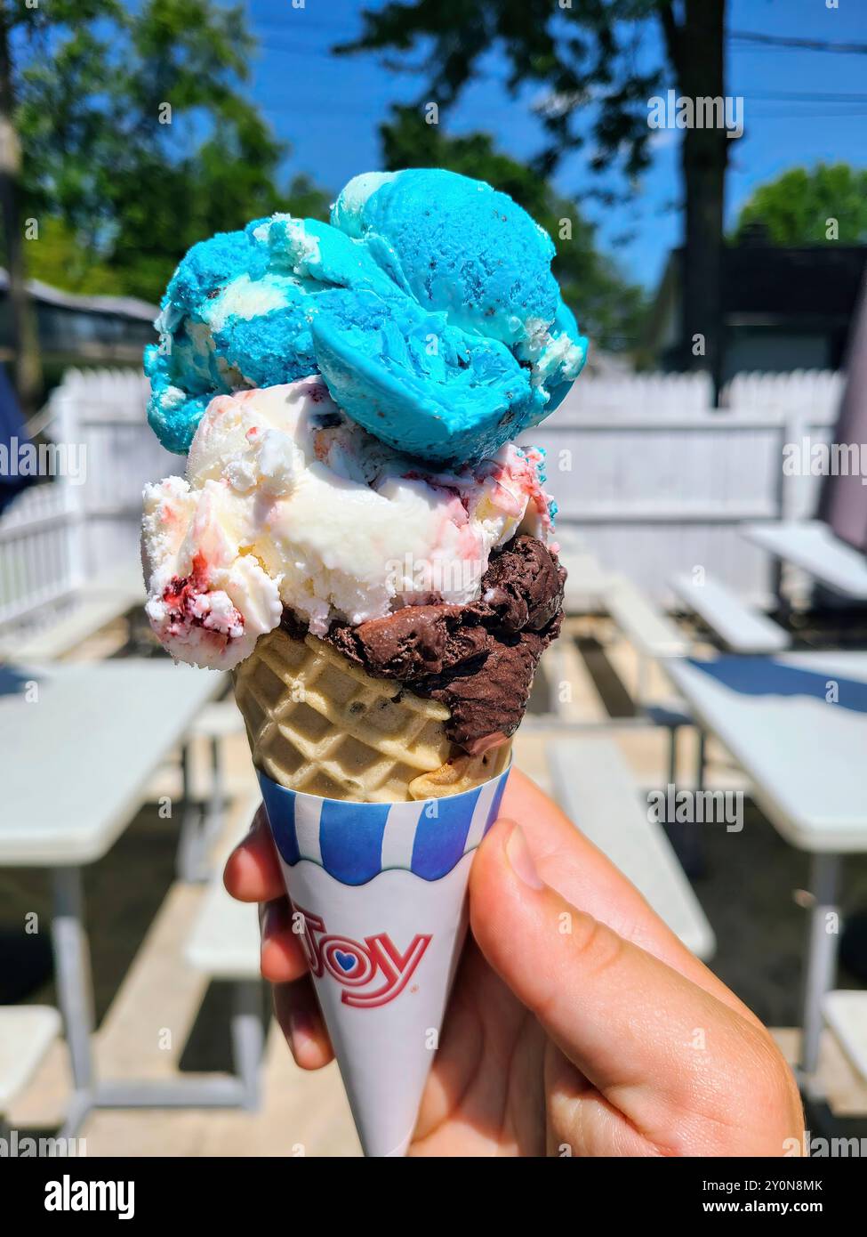 Triple Scoop Ice Cream Cone in Hand at Eye Level Stock Photo - Alamy