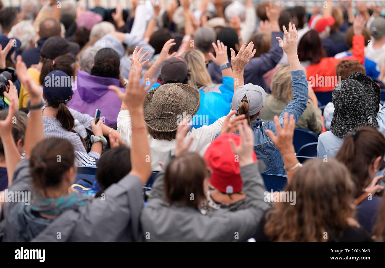 Spectators waves their hands as part of a silent applause during the ...