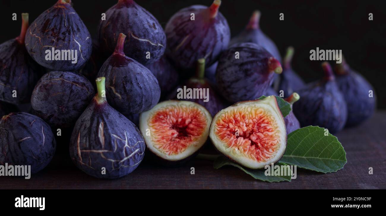 Freshly picked purple figs with leaf against dark background Stock ...