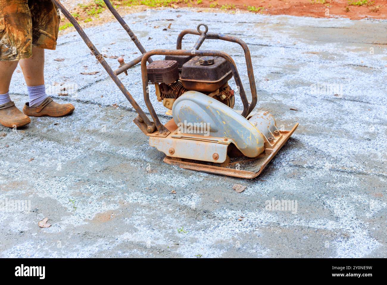 Vibratory tamping machine compacting sand during construction of pool ...