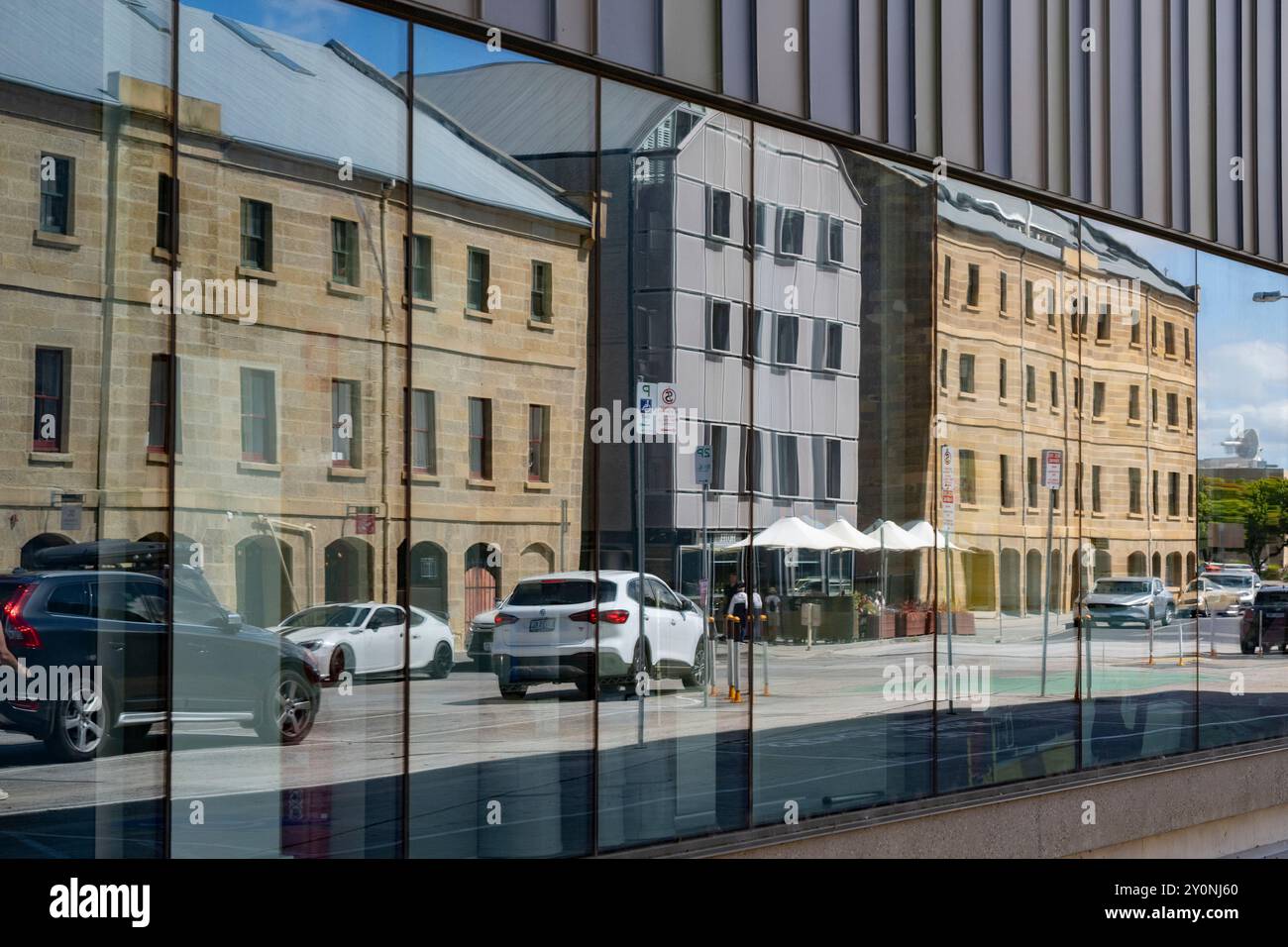 Reflection in a window of traffic on the road and buildings in the City ...