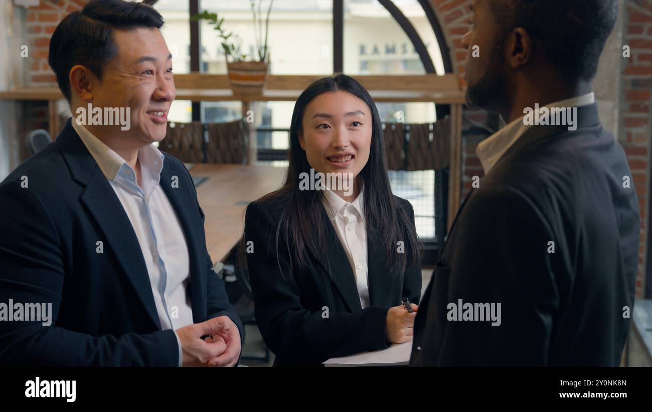 Three multiracial business people in office teamwork meeting Asian man ...