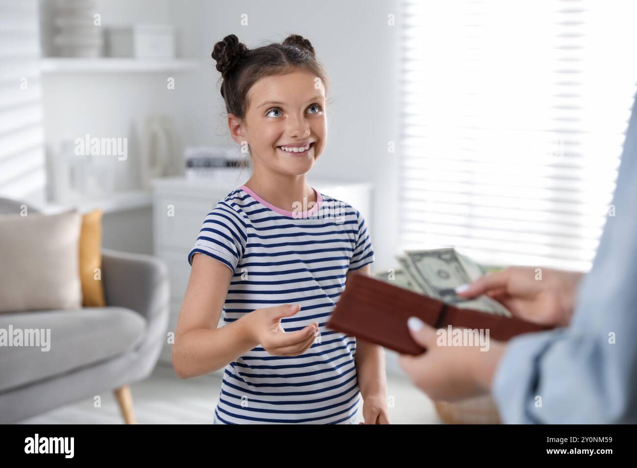 Mother giving pocket money to her daughter at home Stock Photo - Alamy