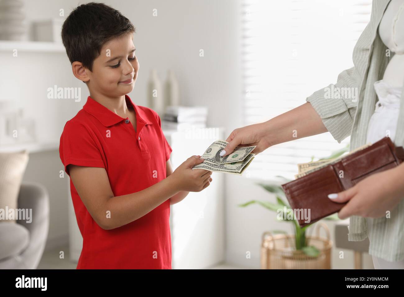 Mother giving pocket money to her son at home Stock Photo - Alamy