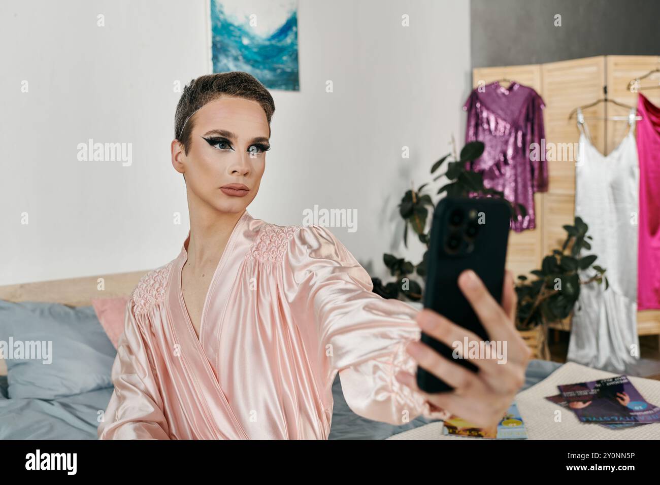 A confident drag queen poses while taking a selfie in a chic setting ...