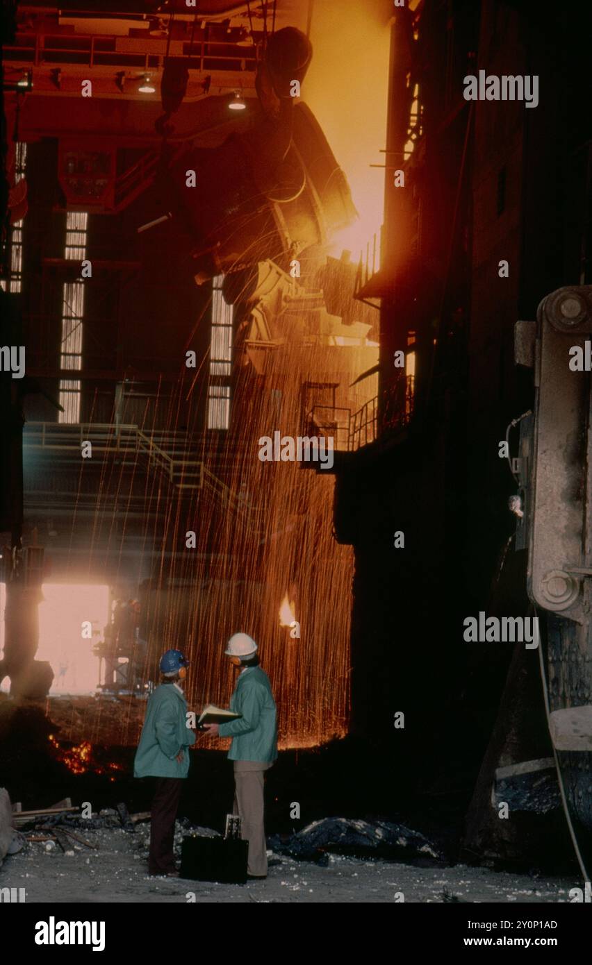 Customer and salesman in steel mill watching pour Stock Photo - Alamy