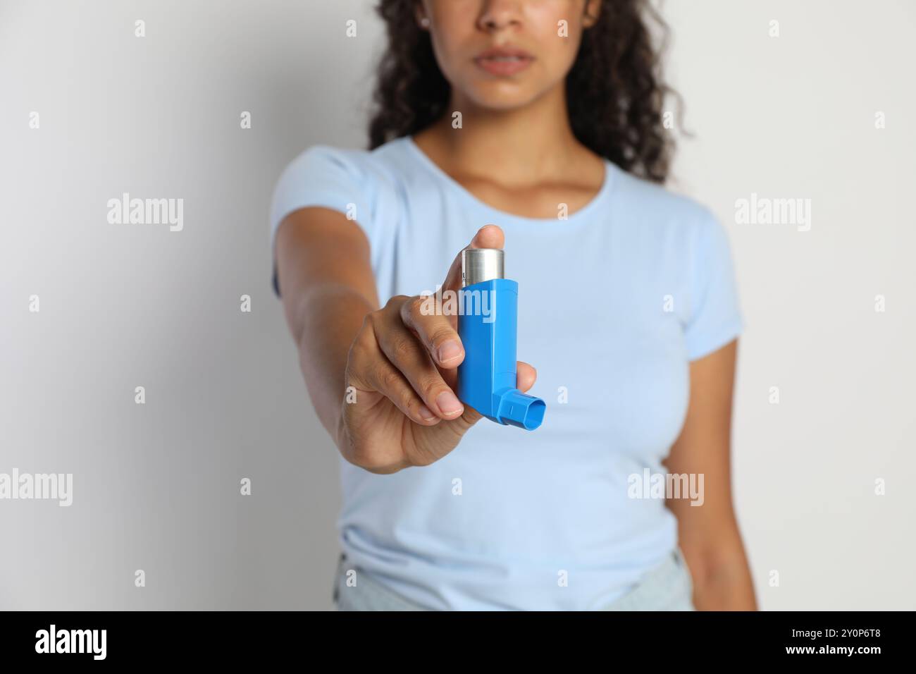 Woman holding asthma inhaler on light grey background, closeup Stock ...