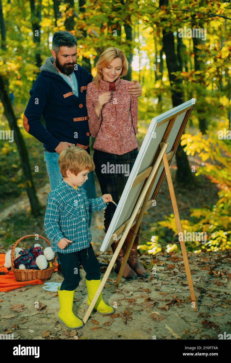 Blonde cute smart son drawing his family giving joyful moments to mom ...