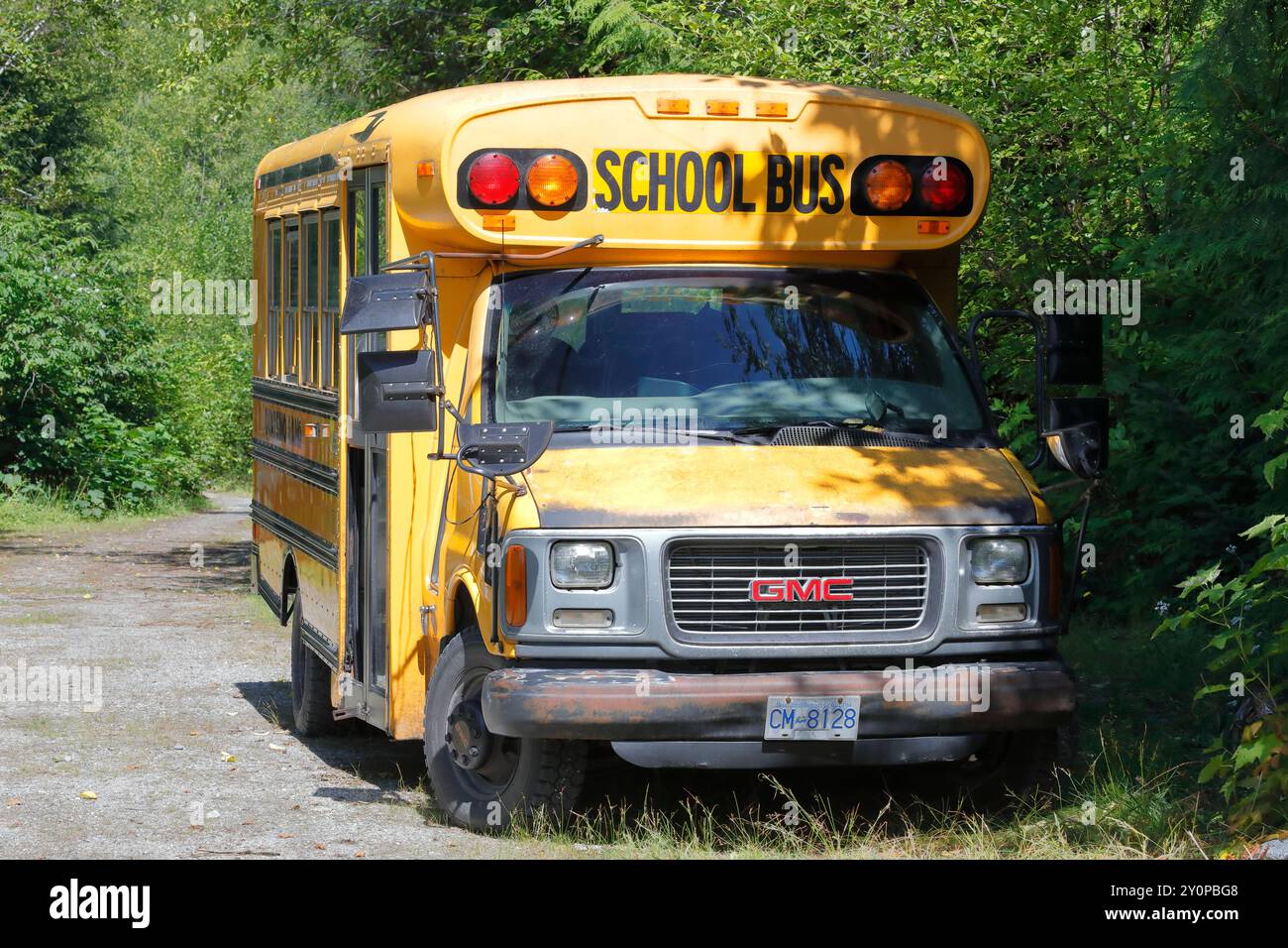 A yellow Canadian GMC school bus, repurposed as a passenger truck to ...