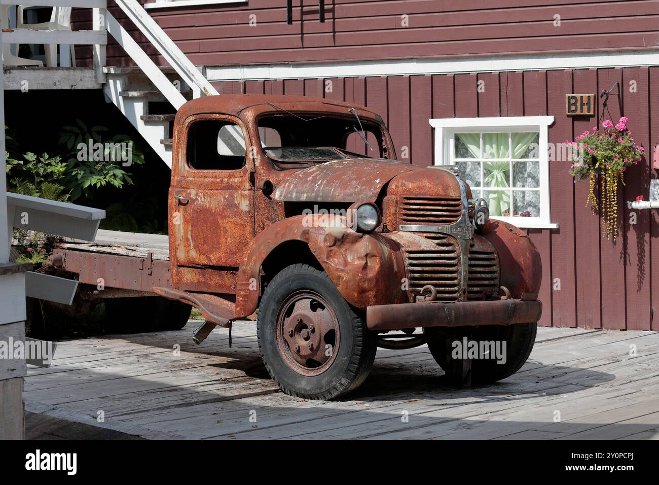 A rusty disused Dodge logging truck standing on wooden decking in front ...