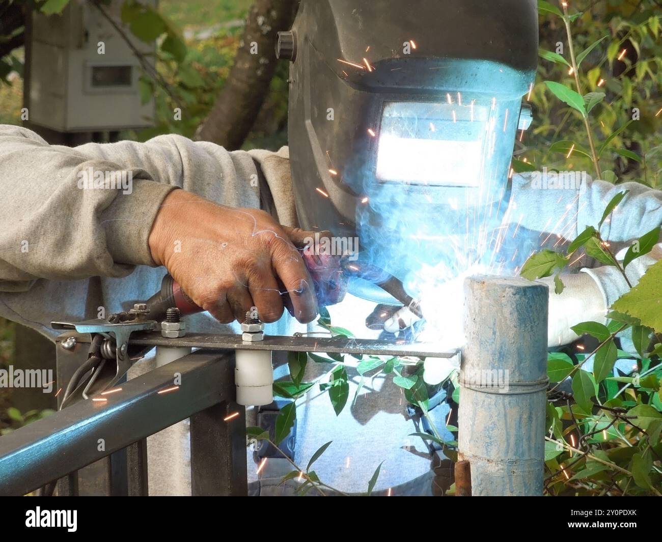 unrecognized man welding a metal gate in countryside yard Stock Photo ...