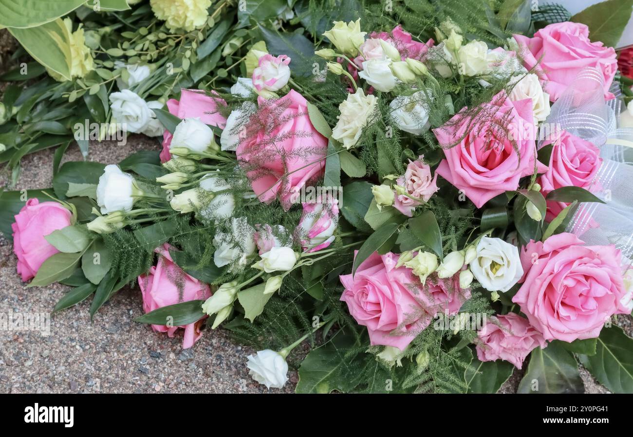 Beautiful grave flowers in the cemetery. Relatives want to remember the deceased with flowers. A ...