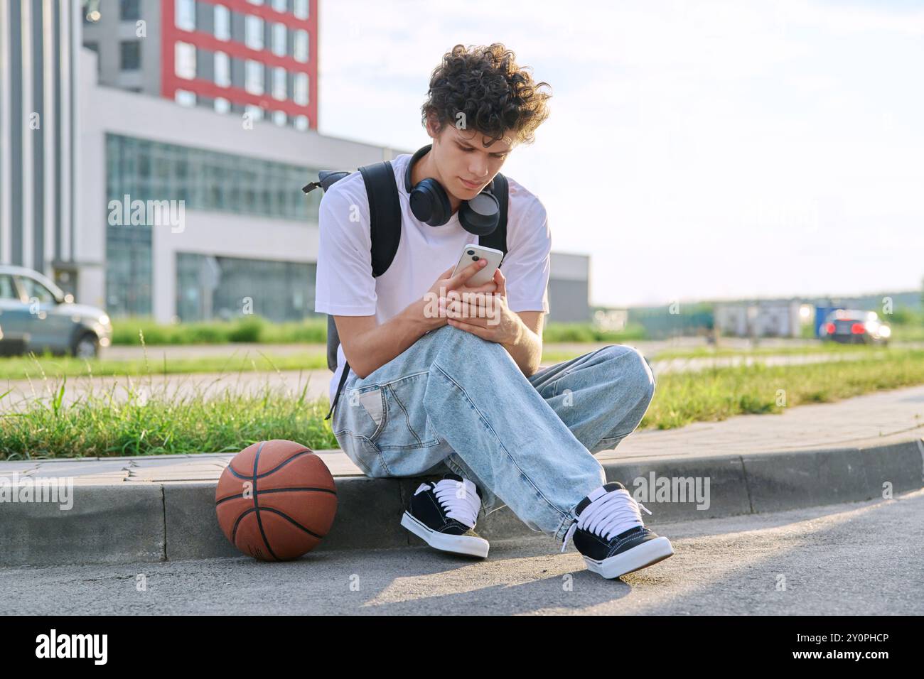 Young guy using smartphone, modern city street background Stock Photo ...