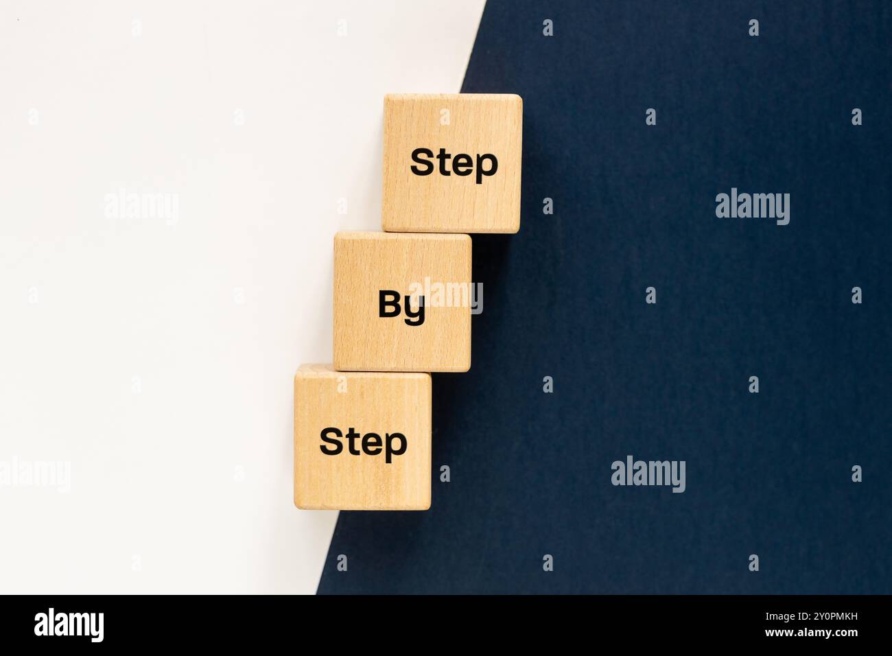 The words step by step on wooden blocks against navy blue and white ...