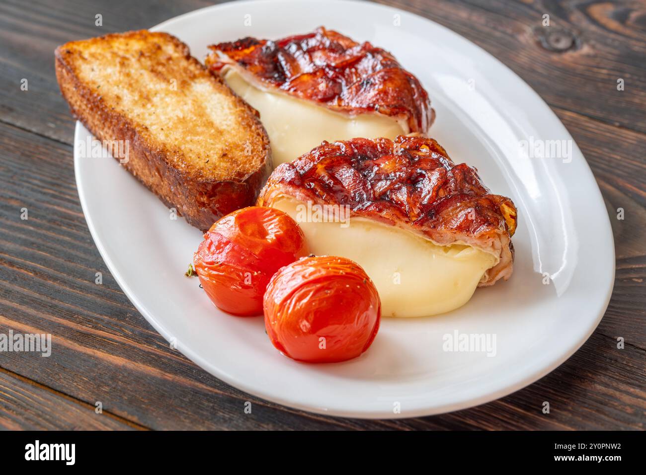 Camembert cheese wheel wrapped in glazed bacon Stock Photo - Alamy