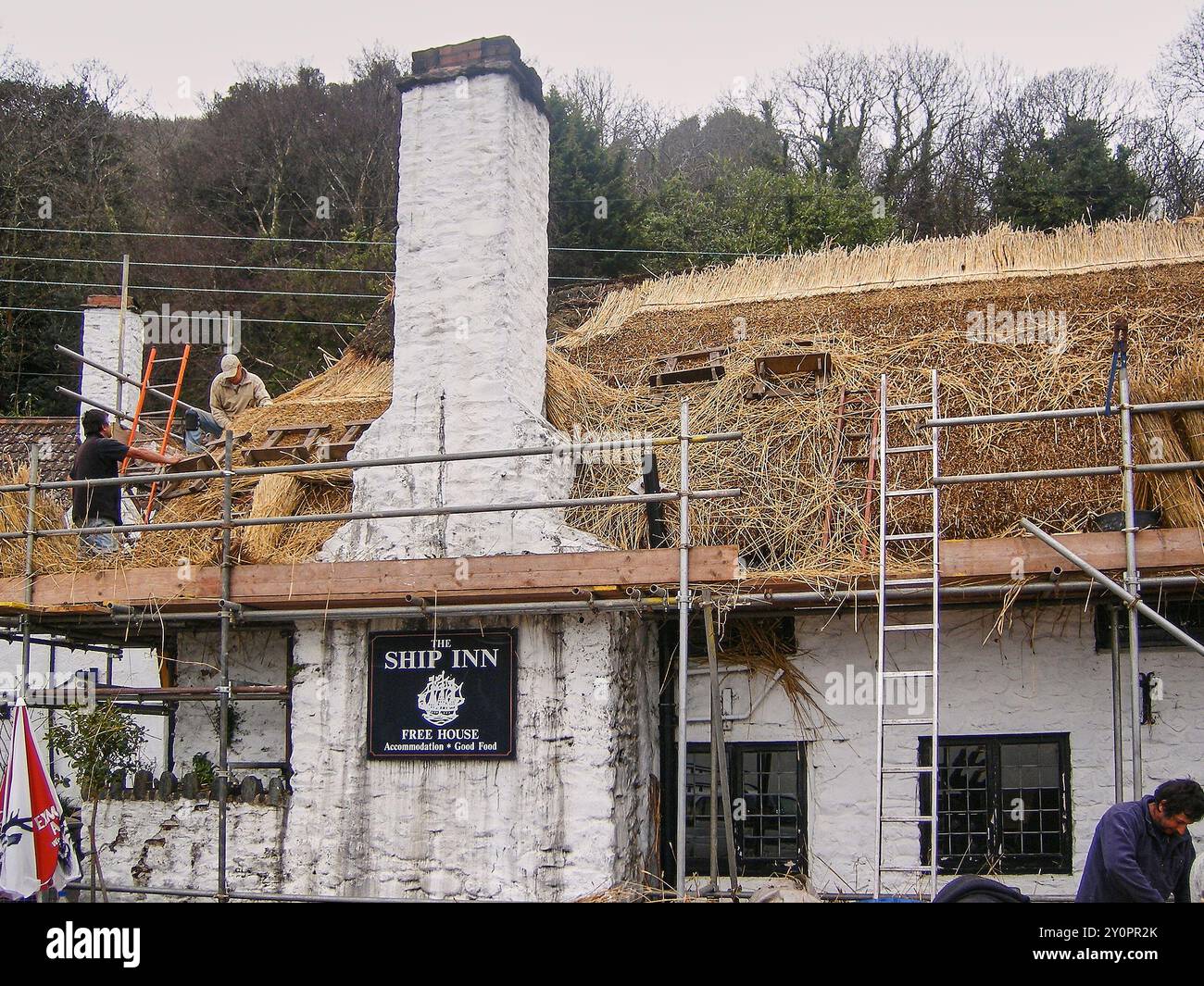 Thatchers repairing the roof of the Ship Inn public house, Porlock Weir ...