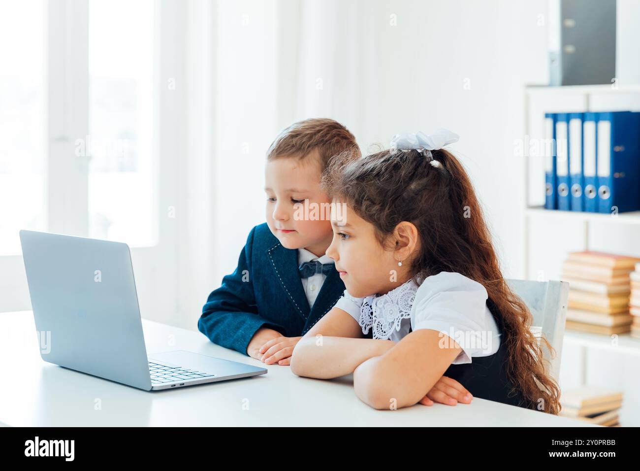 Boy and girl studying at a table with a laptop Stock Photo - Alamy