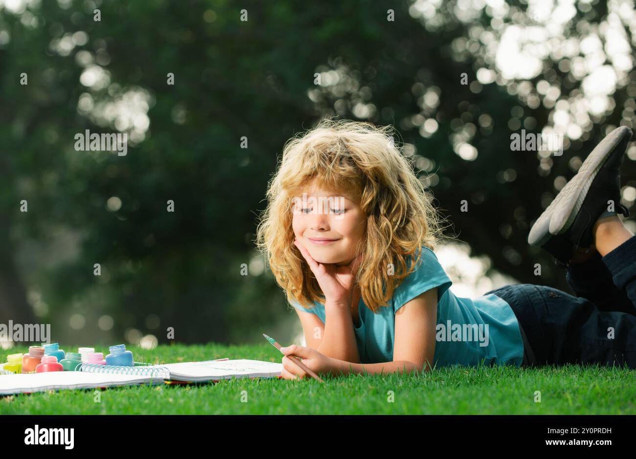 Child drawing. Kids painting with paints color and brush in park ...