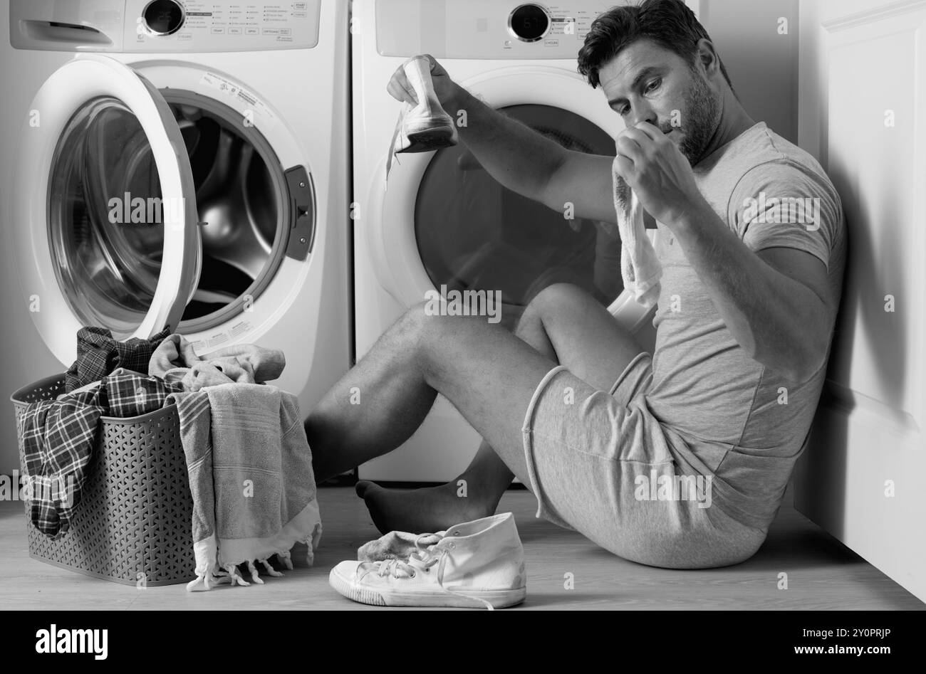 Man with clothes near washing machine. Laundry cleaning. Housework ...