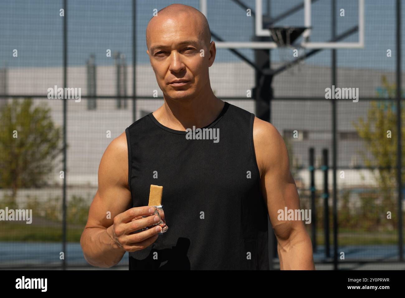 Sportsman eating energy bar. Muscular athlete snacks on protein bar ...