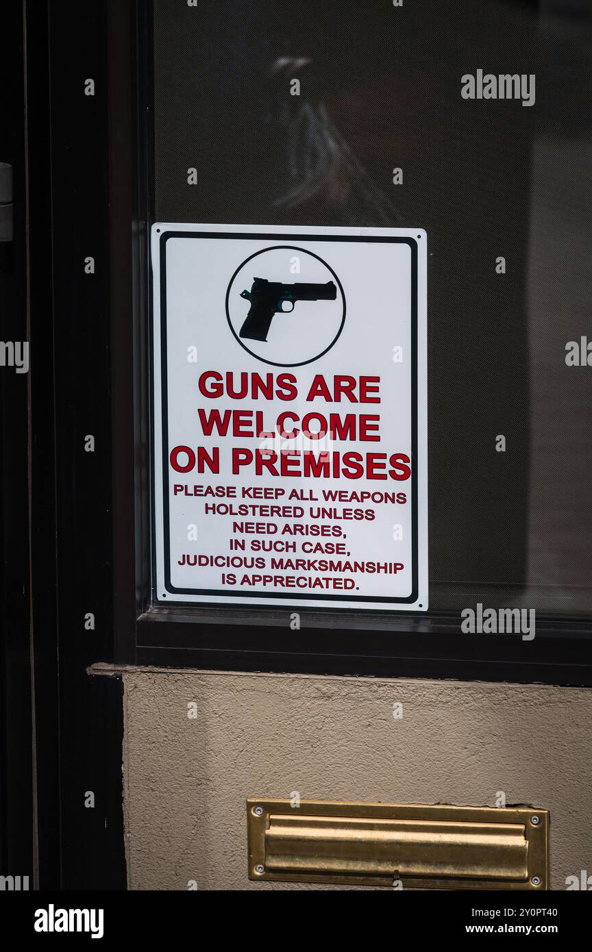 A guns are welcome sign on a store front window Stock Photo - Alamy