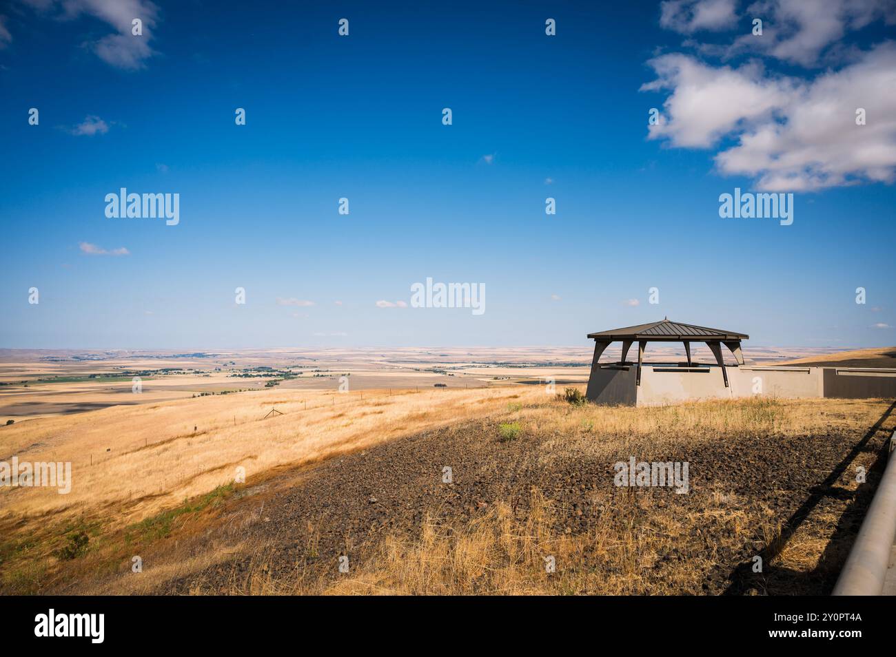 A woman looks out over the Oregon prairie and farm land from a highway ...