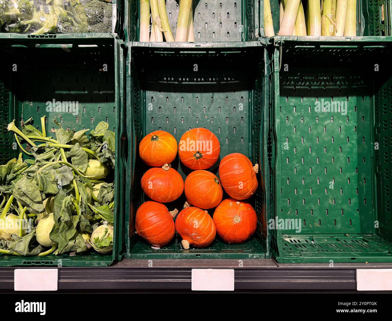 Ripe Hokkaido pumpkins and other vegetables on a shelf in a grocery ...