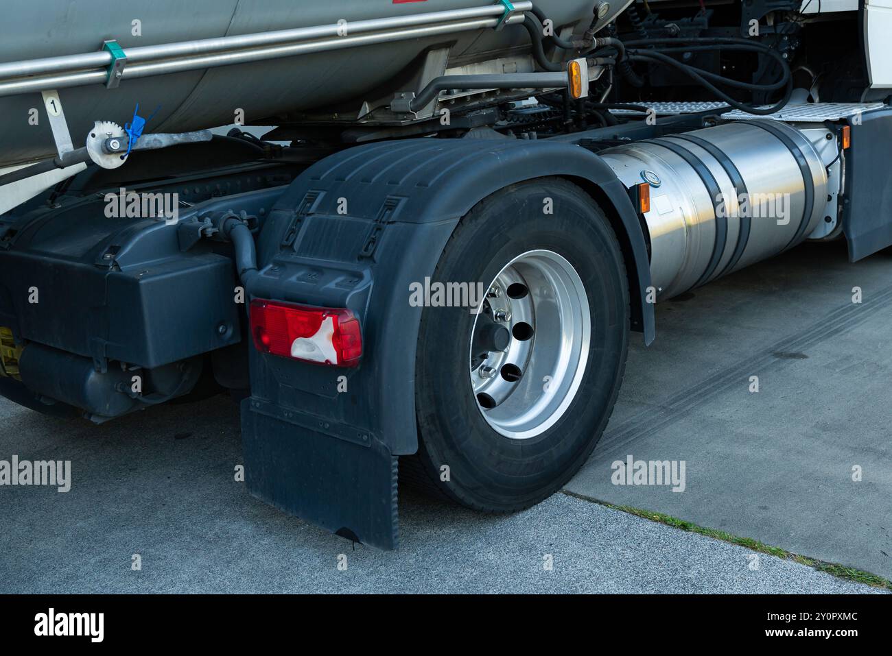 Close-up of the rear wheel and fuel tank of a tanker truck, showing the ...