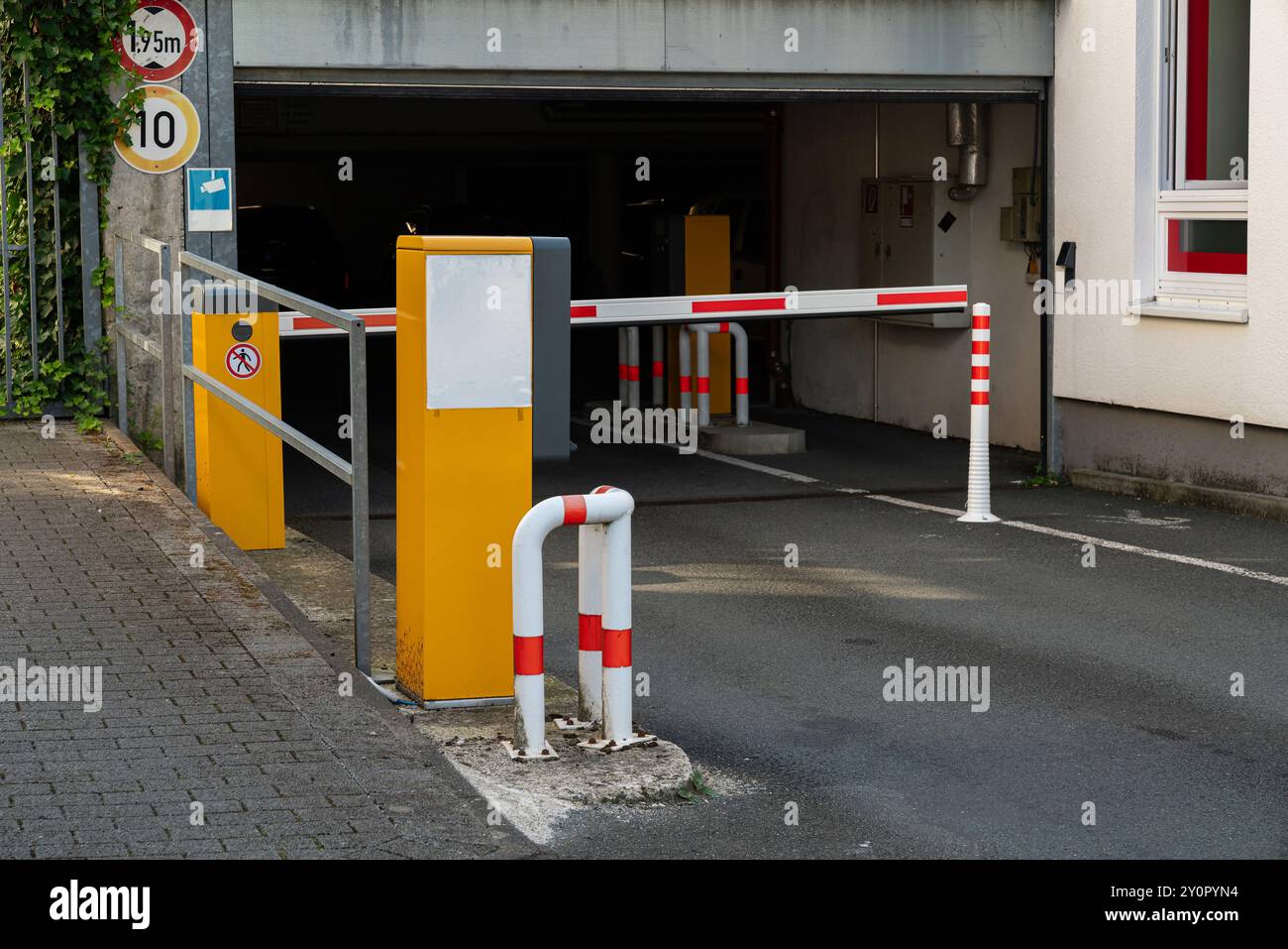 A yellow and white parking gate with red stripes barrier stands next to ...