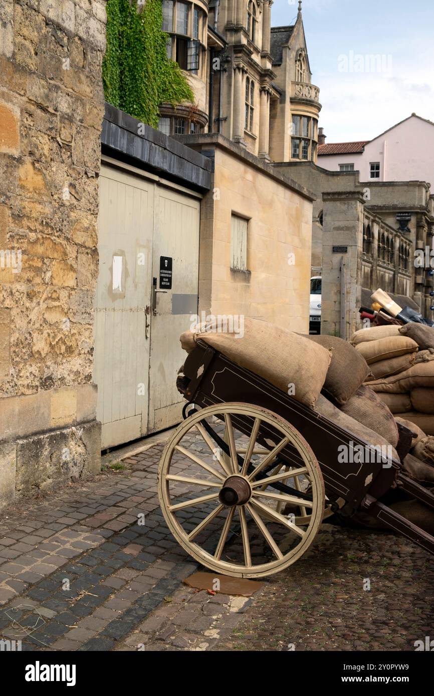 View of wooden wheel on cart laden with hessian sacks on a cobbled lane ...