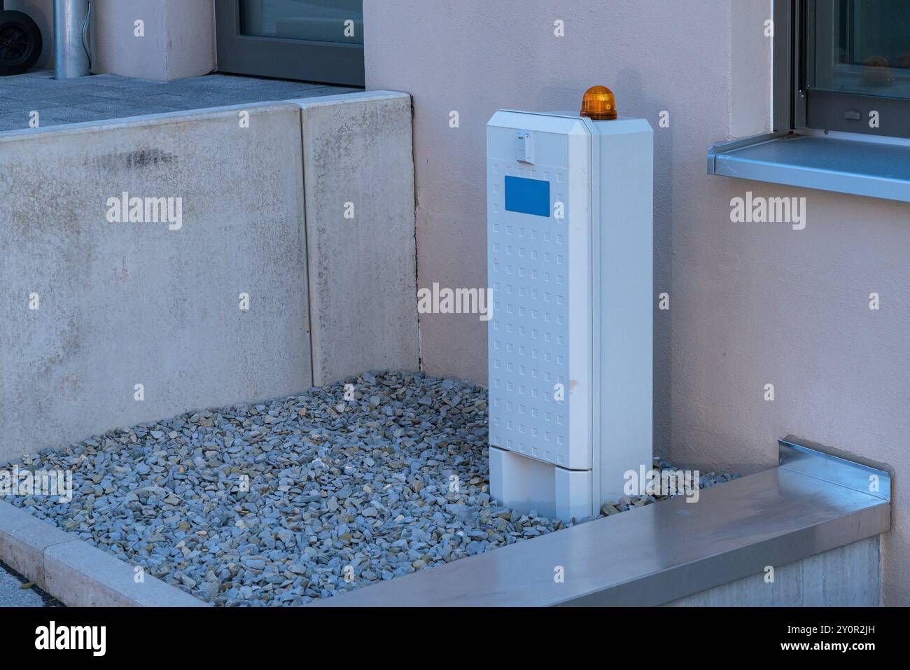 A orange emergency flashing light at the top of an outdoor alarm box ...