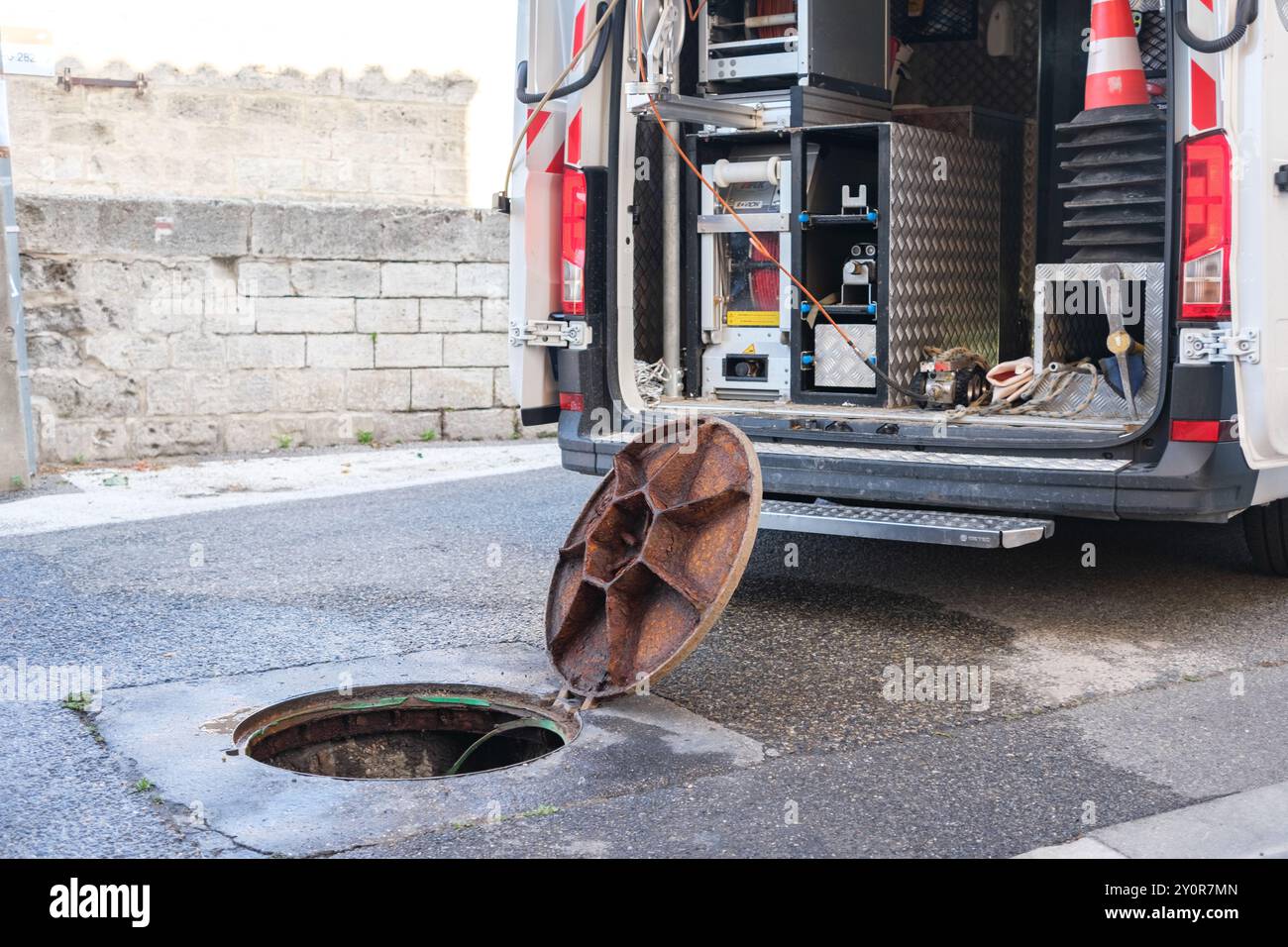 Open manhole cover and workers with repair tools Stock Photo - Alamy