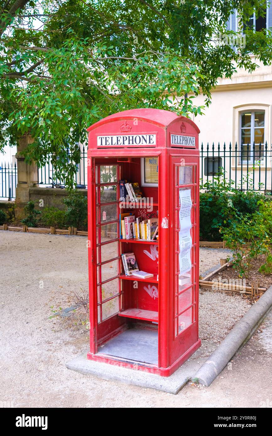 A typical old London telephone booth, located in a park as a book ...