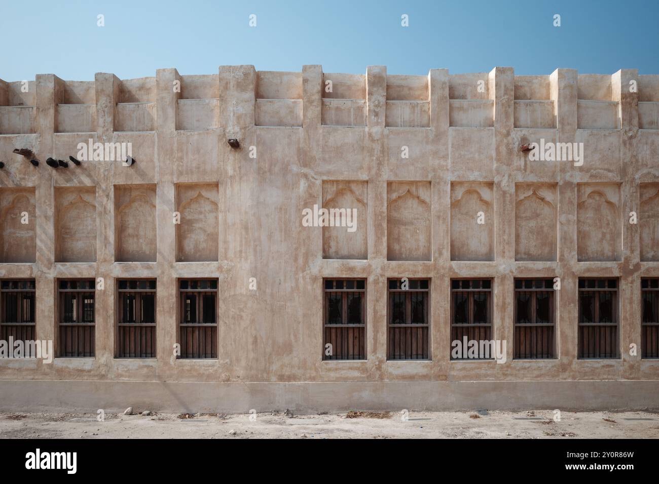 The exterior of a traditional Middle Eastern mud brick building with a ...