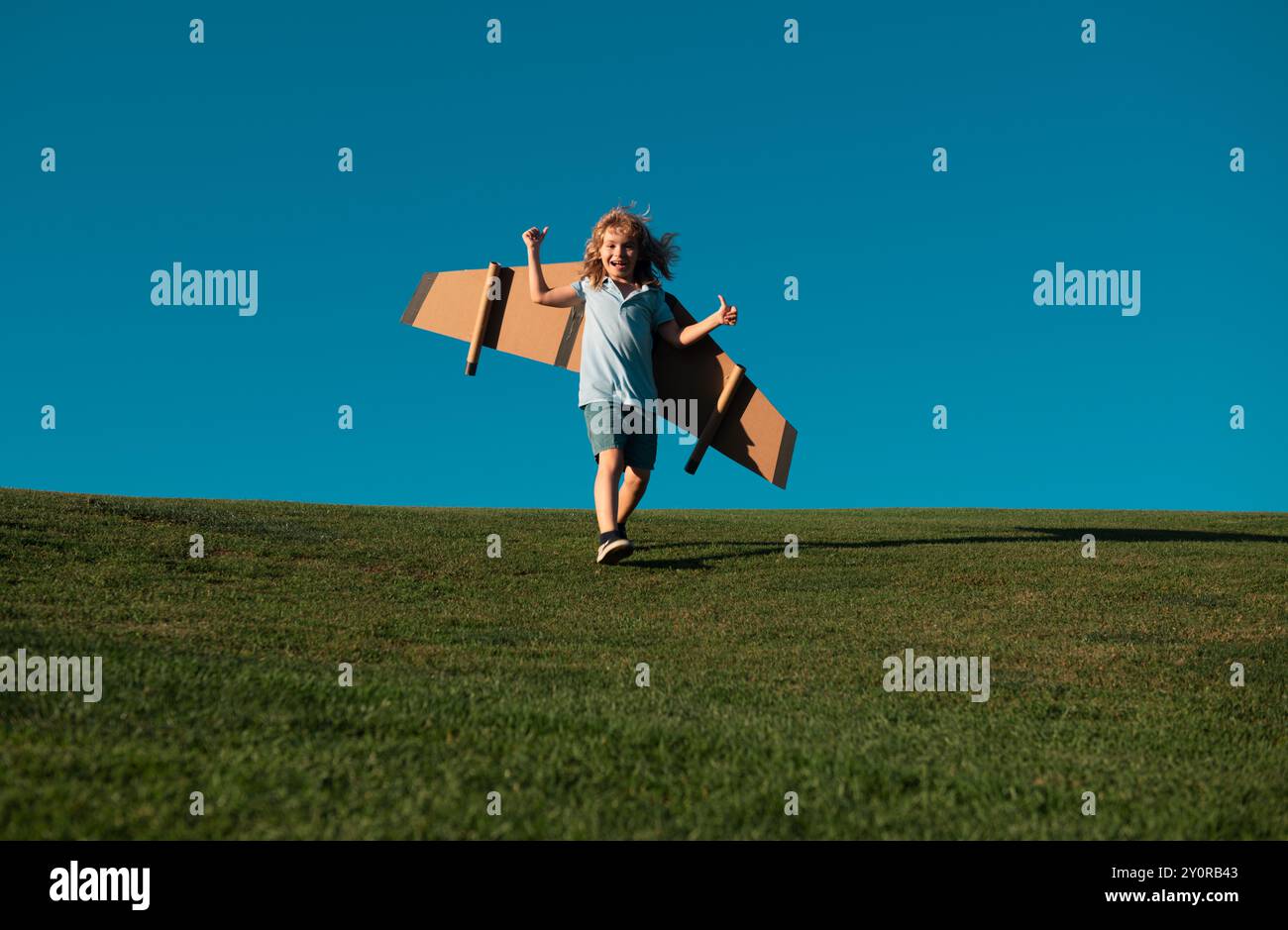 Child boy jumping and running with toy airplane wings. Dream of ...