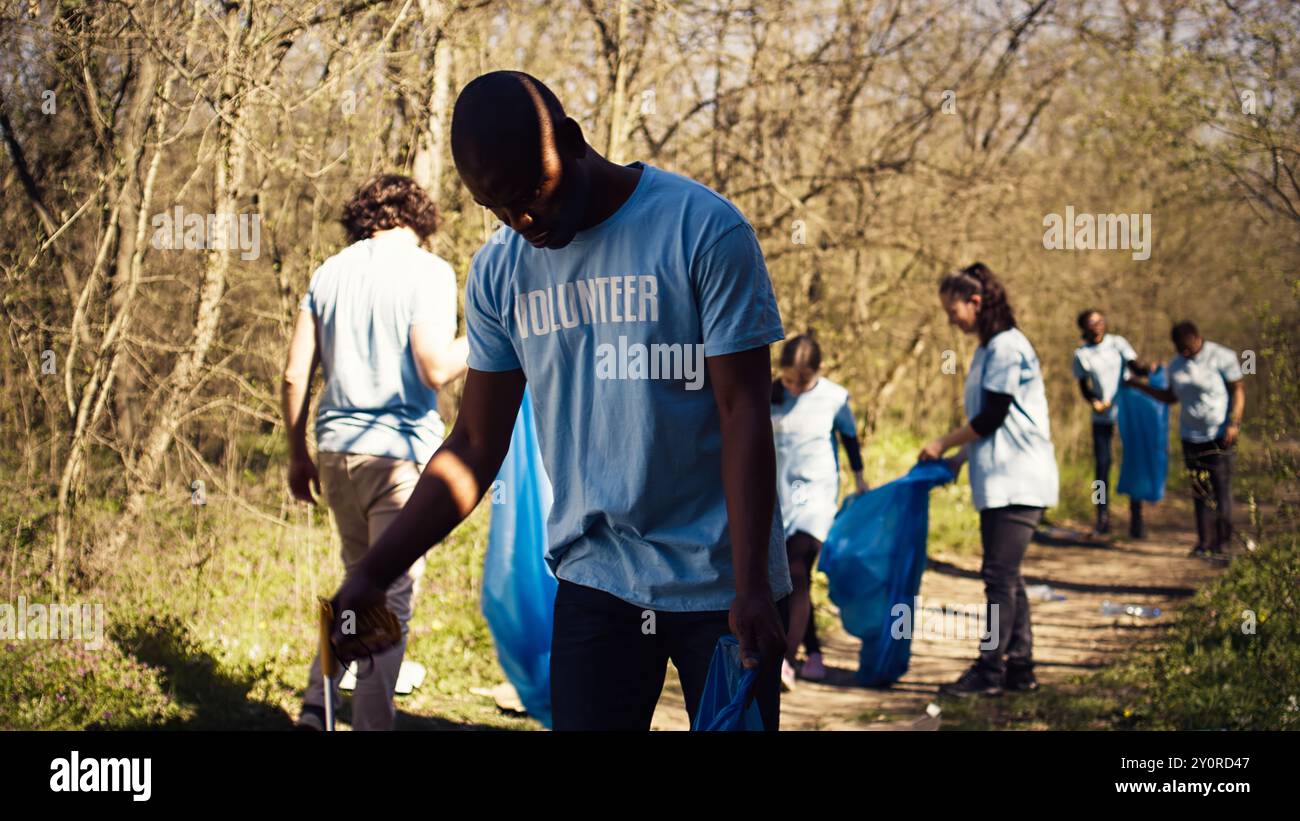 Eco friendly activist grabbing garbage and plastic waste from a forest ...