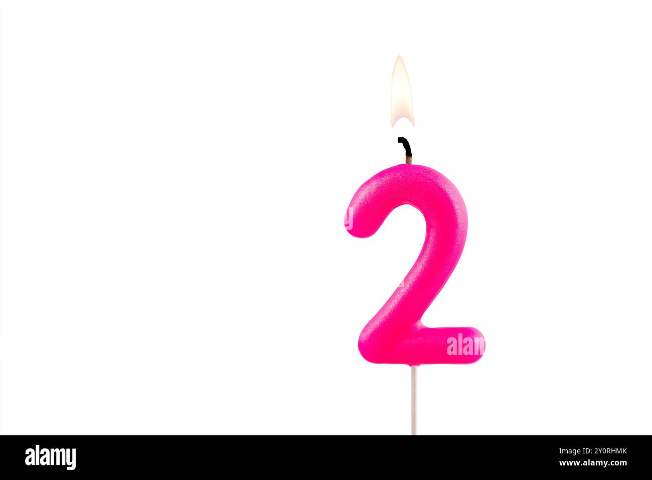 Pink number 2 birthday candle lit on white background Stock Photo - Alamy