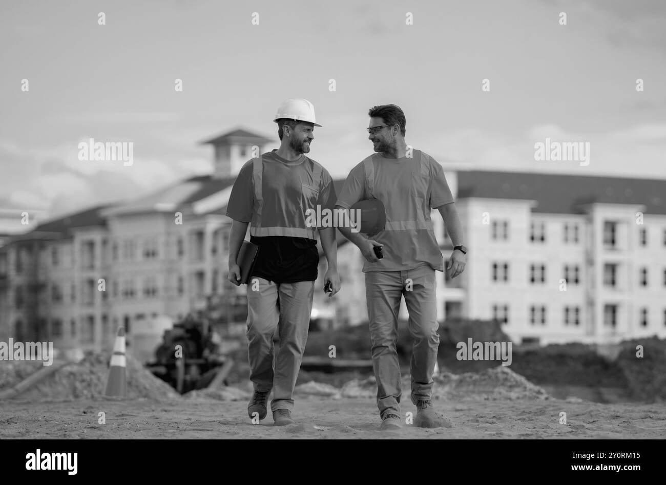 Construction site workers in a helmet work hard. Two workers in a hard ...