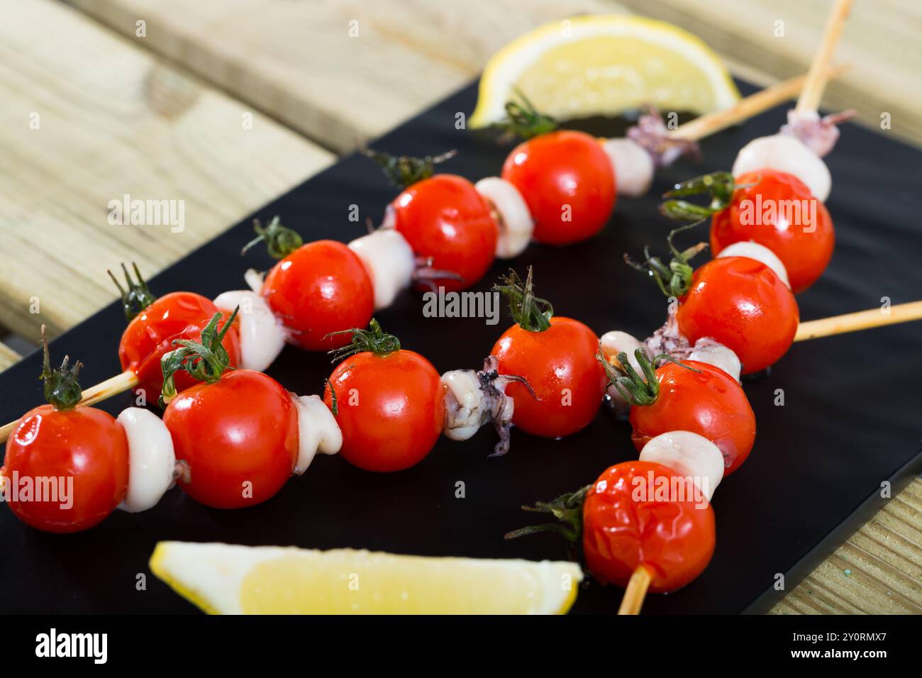 Mini squids with cherry tomatoes Stock Photo - Alamy