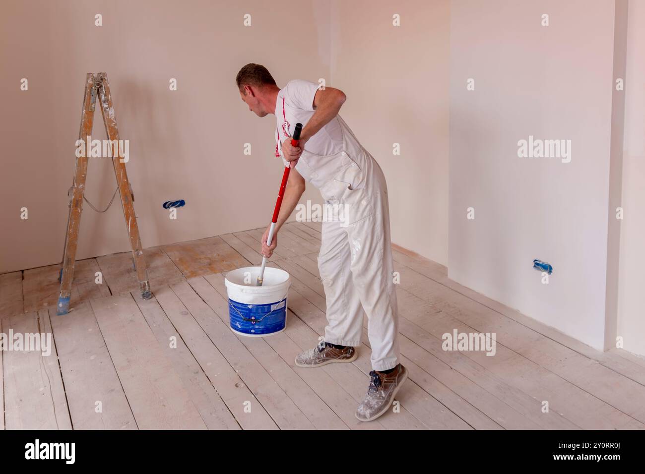 Construction worker painter man with paint roller in his hand and ...