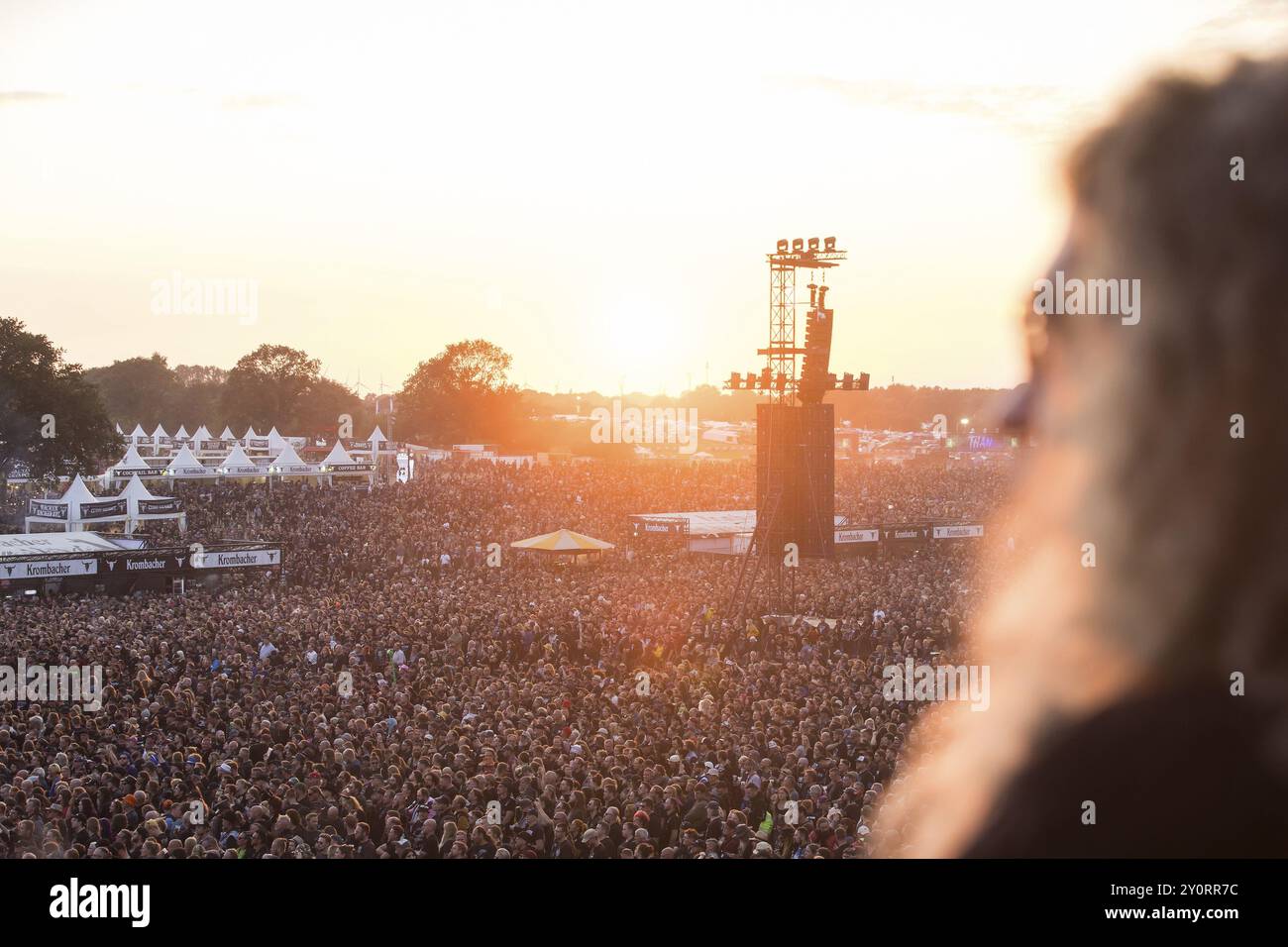A man with long hair looks from an elevated position at the crowd with ...