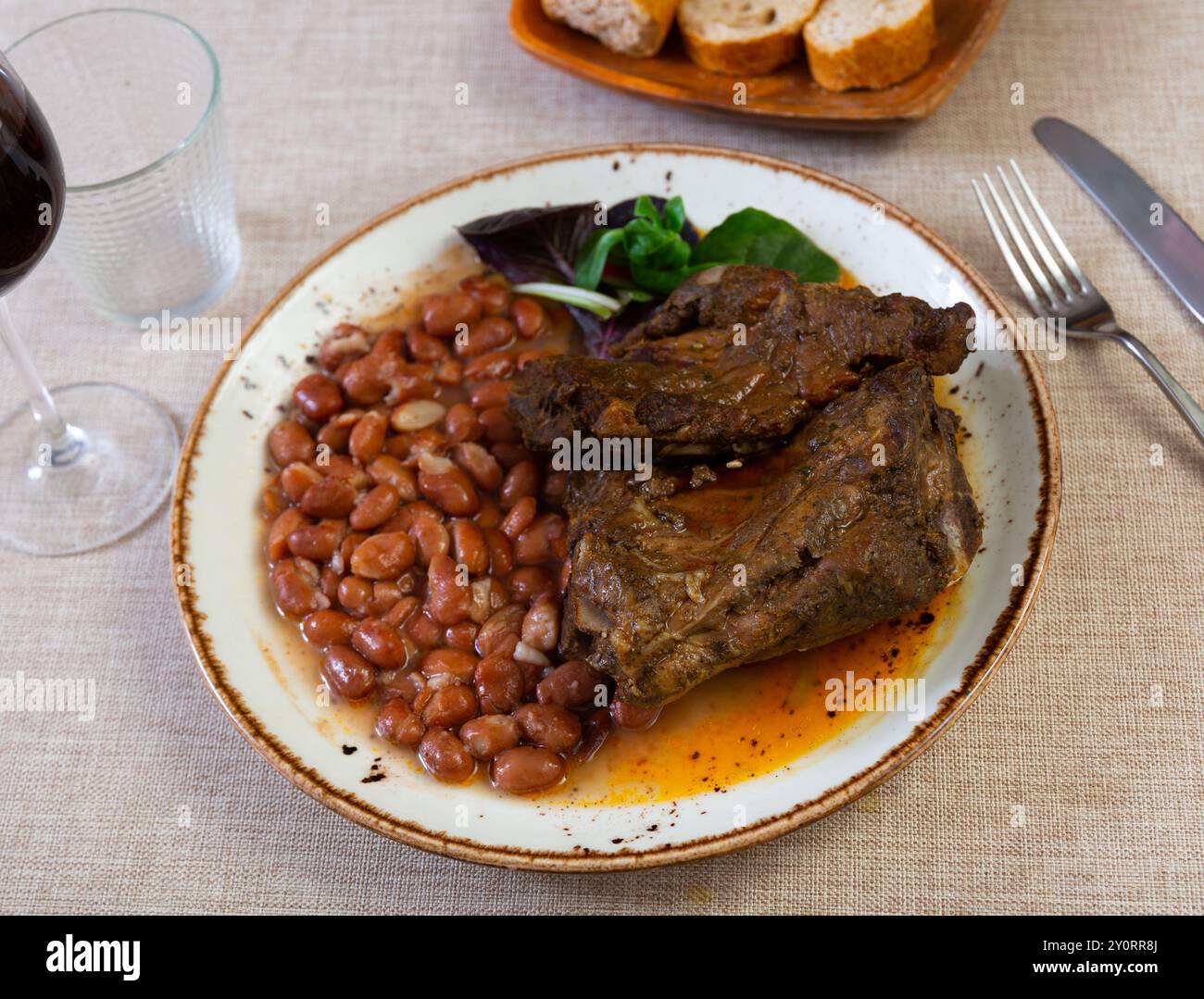 Fried pork served with stewed beans Stock Photo - Alamy
